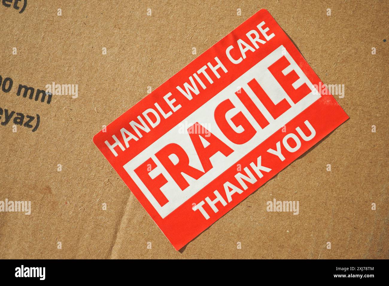 A cardboard box marked with a caution label for fragile goods handling during shipping Stock ...