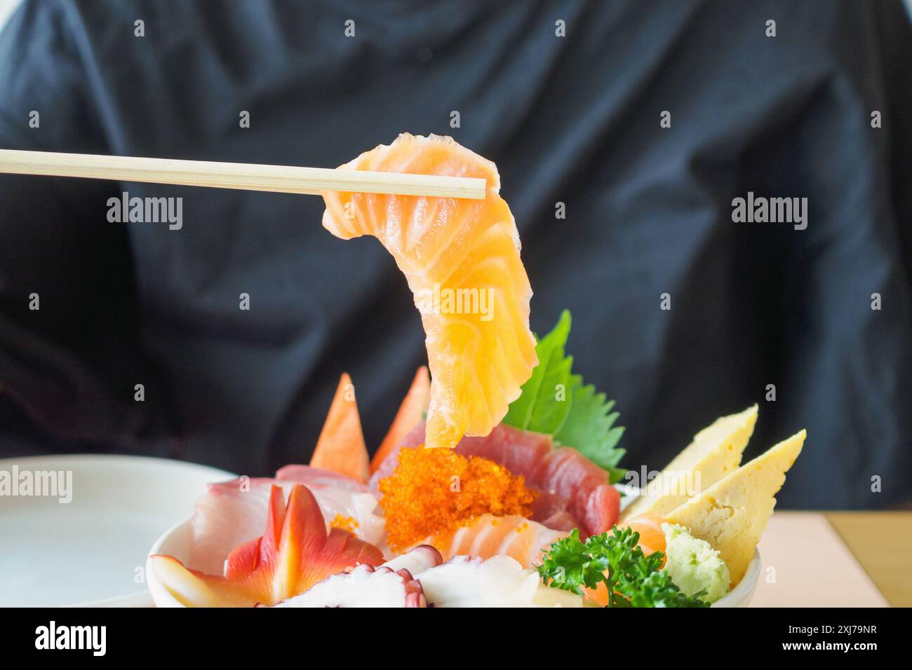 Salmon slice in chopsticks, Eating Sashimi Rice Bowl Chirashi Don ...