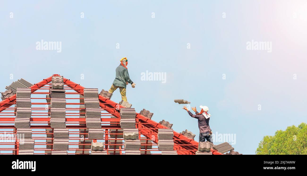 Construction roofer installing roof tiles at house building site Stock ...