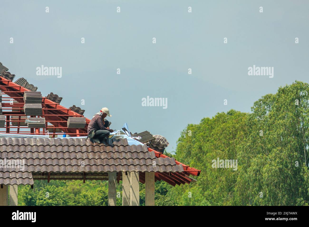 Construction roofer installing roof tiles at house building site Stock ...