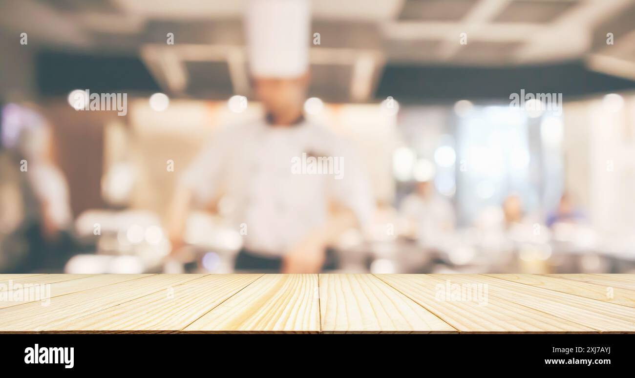 Empty Wood table top with Chef cooking in restaurant kitchen blurred ...