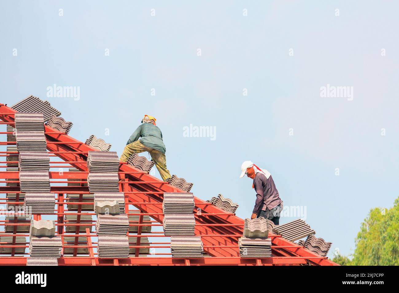 Construction roofer installing roof tiles at house building site Stock ...