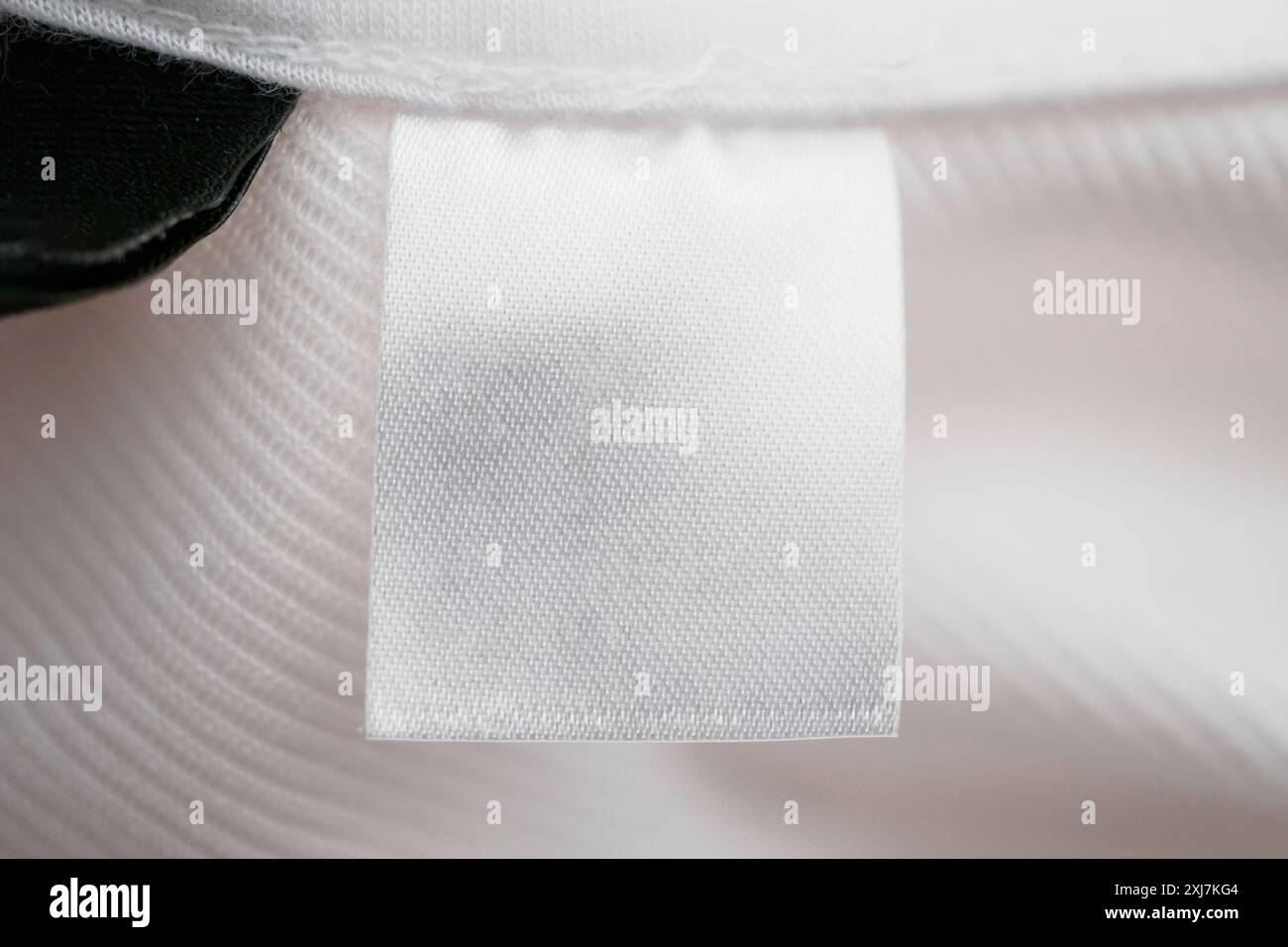 White blank clothing label on cotton shirt background Stock Photo - Alamy