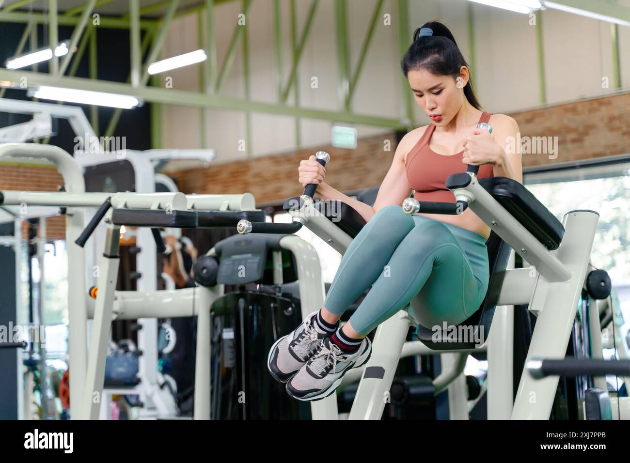 Young beautiful woman lifting her legs to work on her abs strength ...