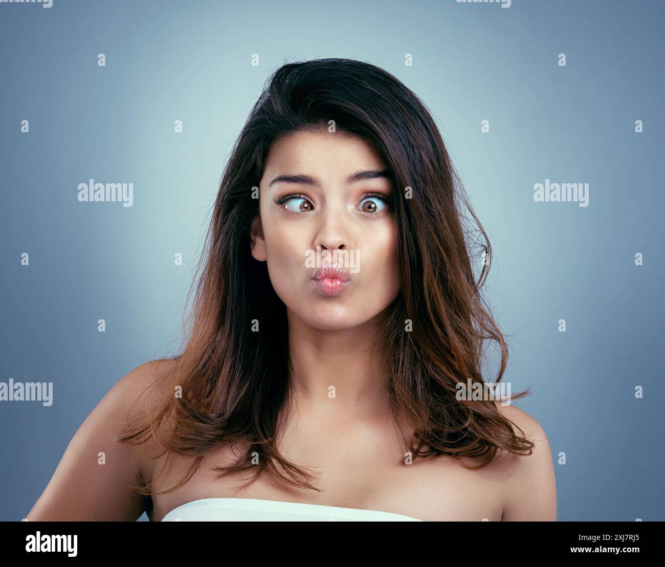 Woman, funny and silly or face in studio, kiss lips and crossed eyes on ...