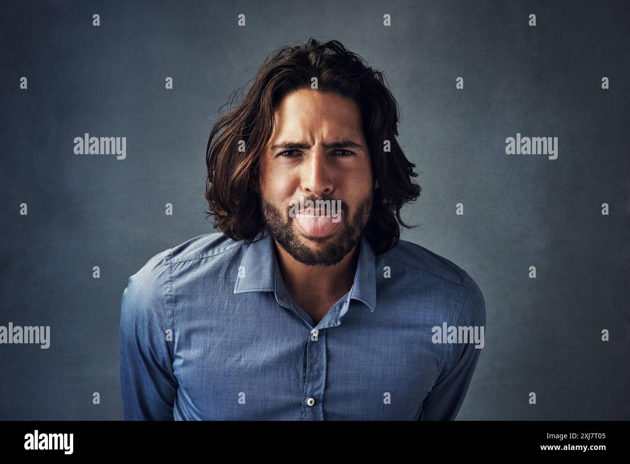 Tongue out, playful and portrait of man in studio with silly, goofy and ...