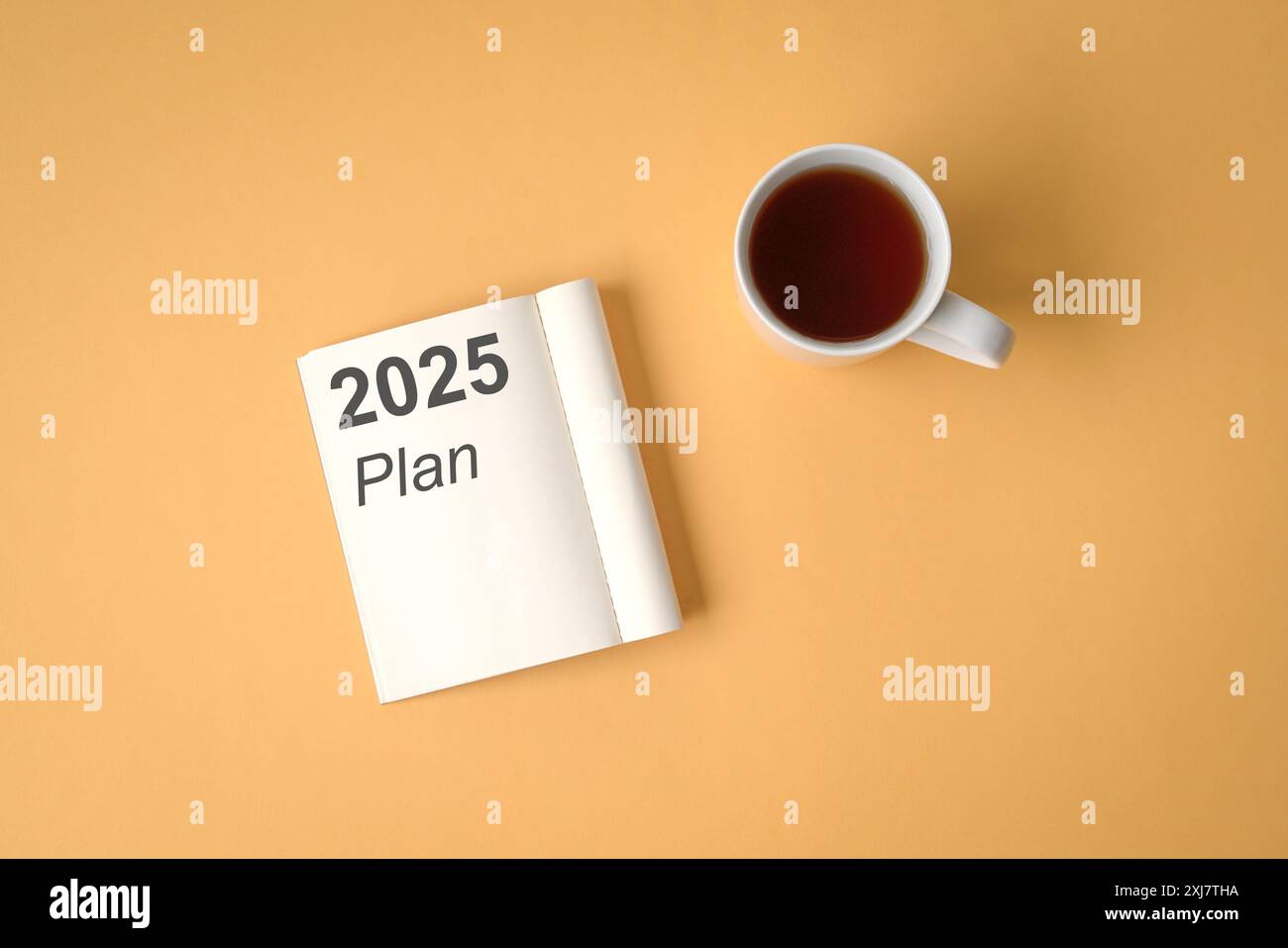 2025 Plan on notepad, with coffee. Top view, on yellow background Stock ...