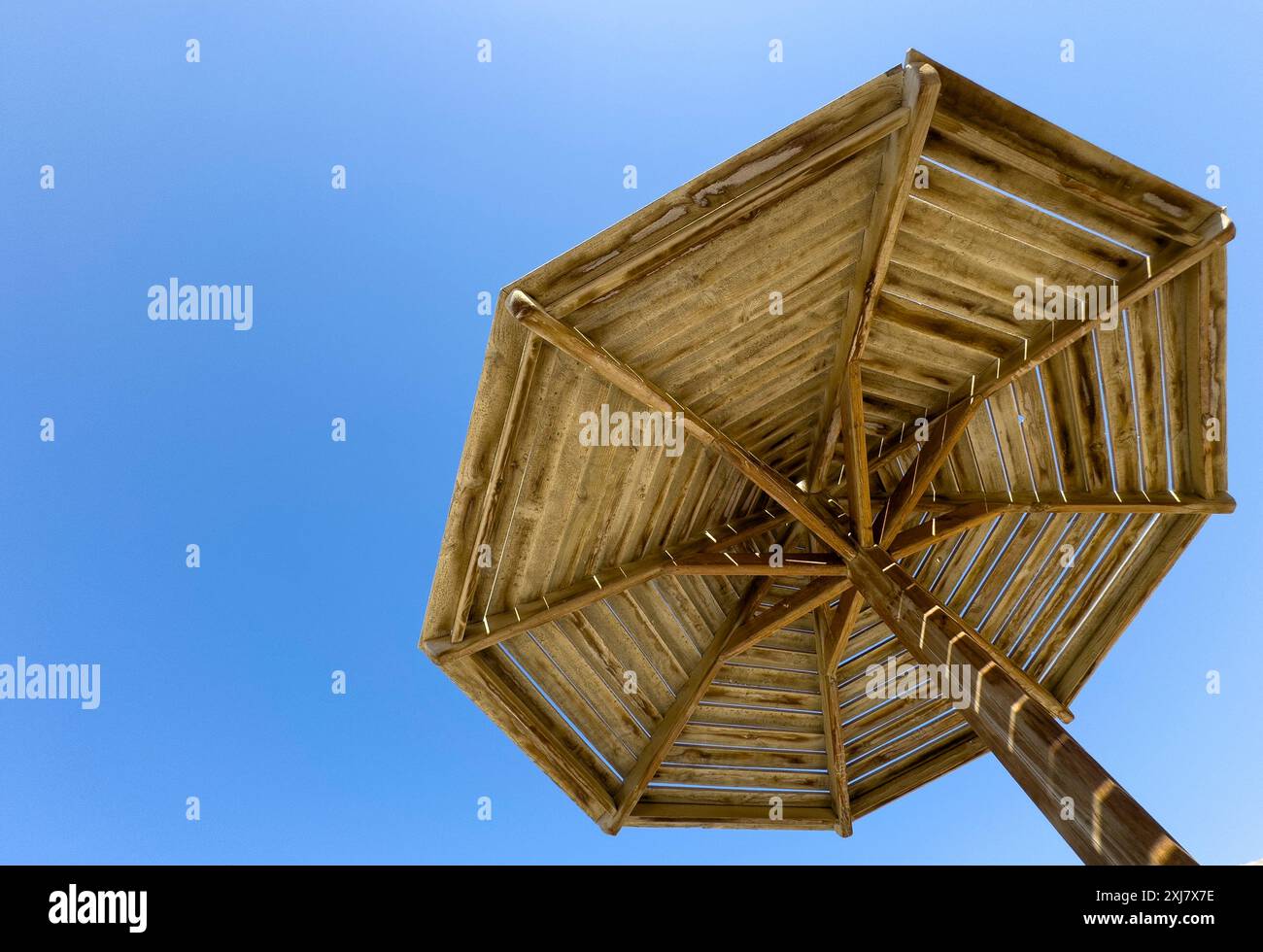 Wooden parasol with blue sky on the beach Stock Photo - Alamy