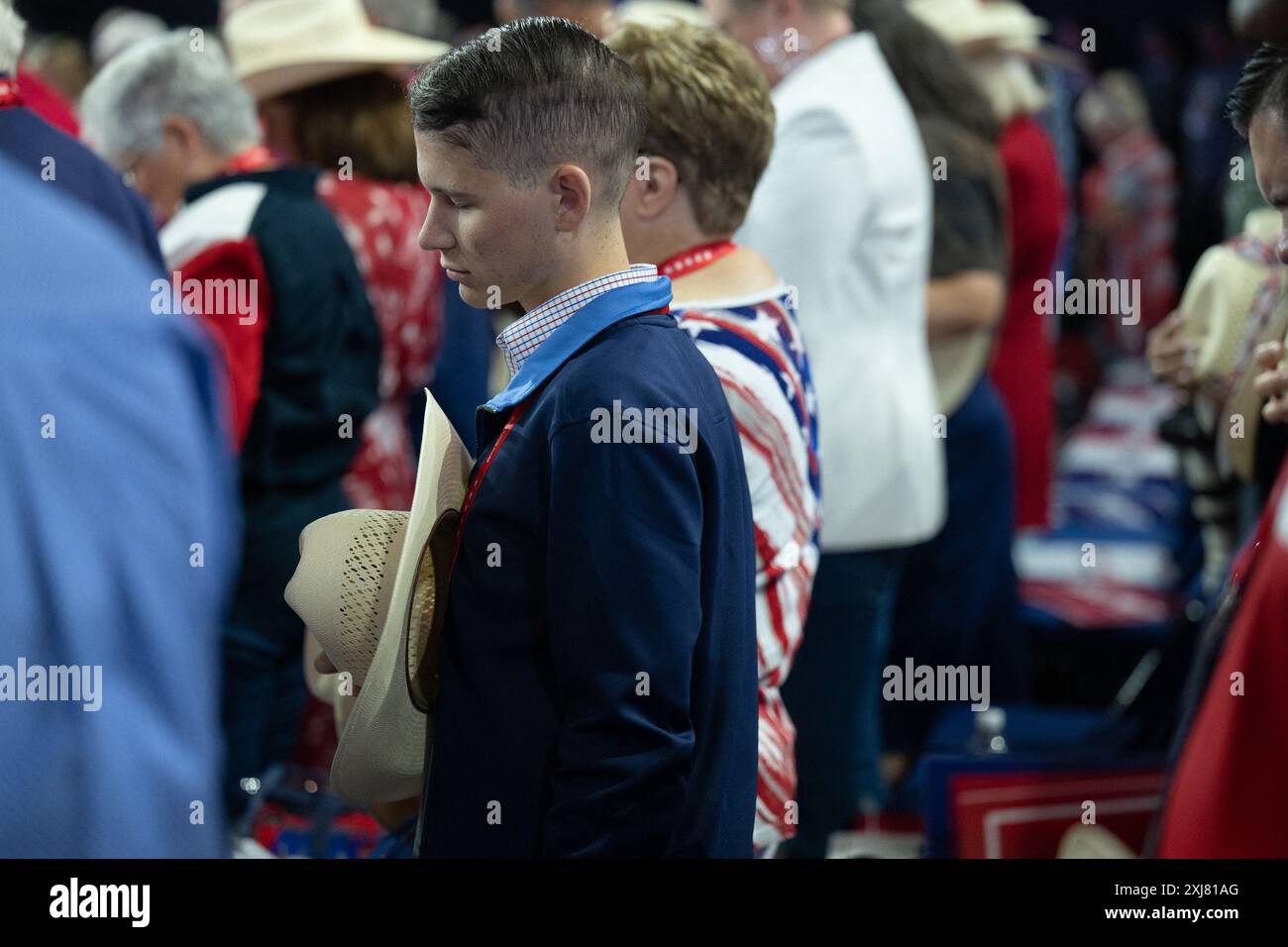 An attendee puts his hat over his chest in prayer at the Republican ...