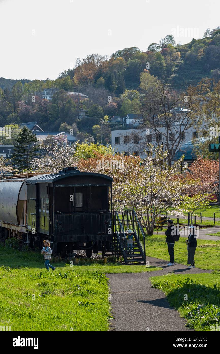 Asian family with two toddlers at an outdoor train carriage display ...