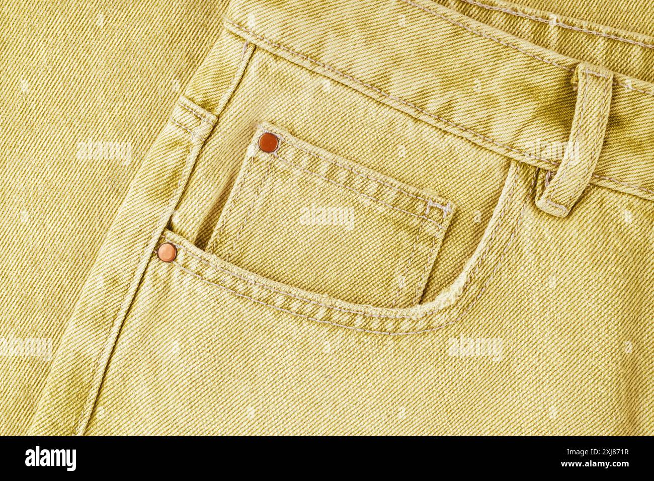 Front pocket and small pocket of yellow jeans pants close up, macro ...