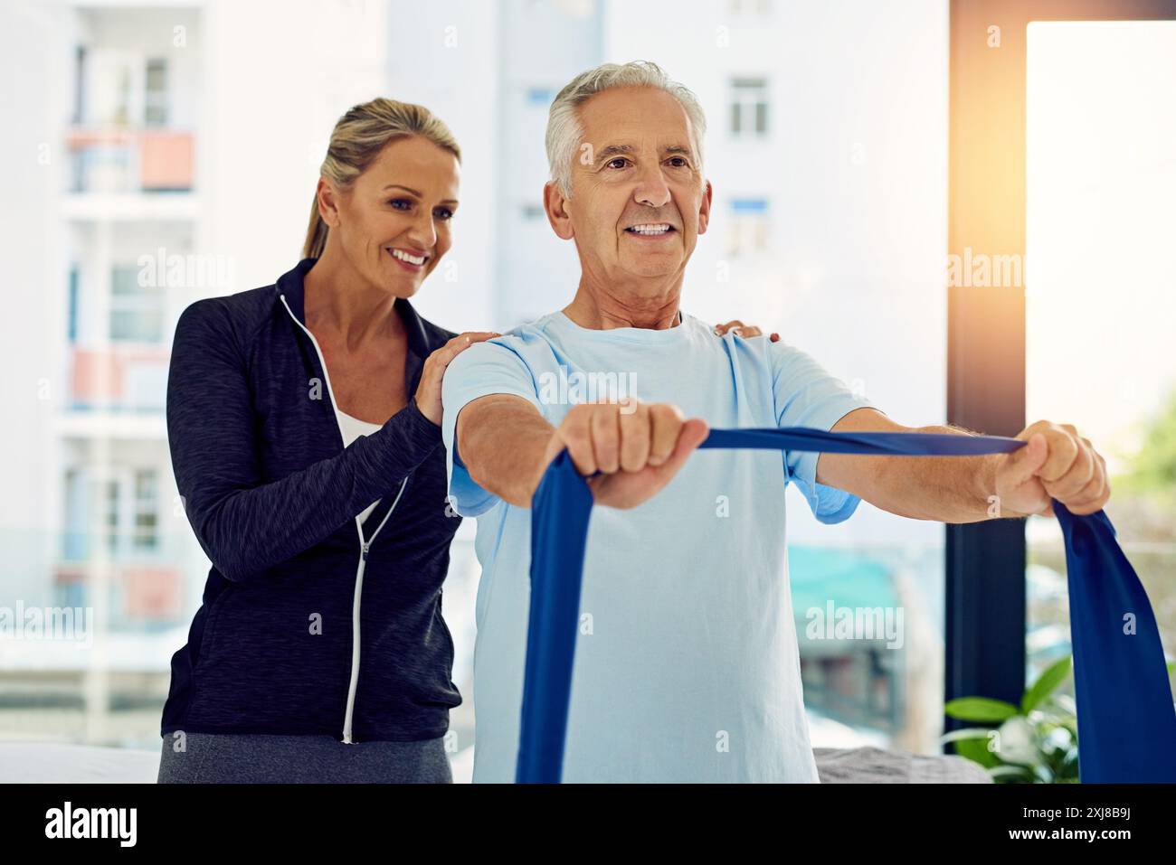 Senior, woman and resistance band with physiotherapist for physical ...