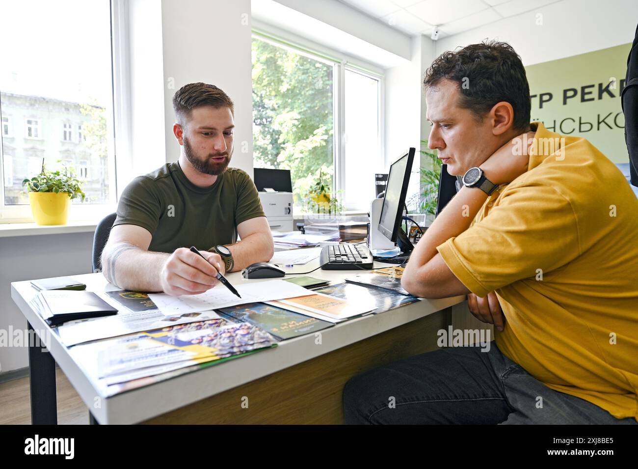 LVIV, UKRAINE - JULY 16, 2024 - An employee speaks to a man at the ...