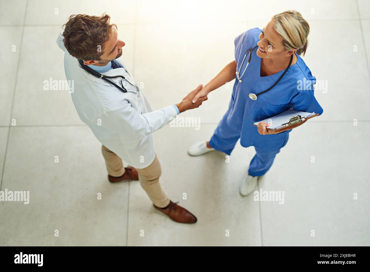 Doctor, nurse and shaking hands for teamwork, partnership or ...