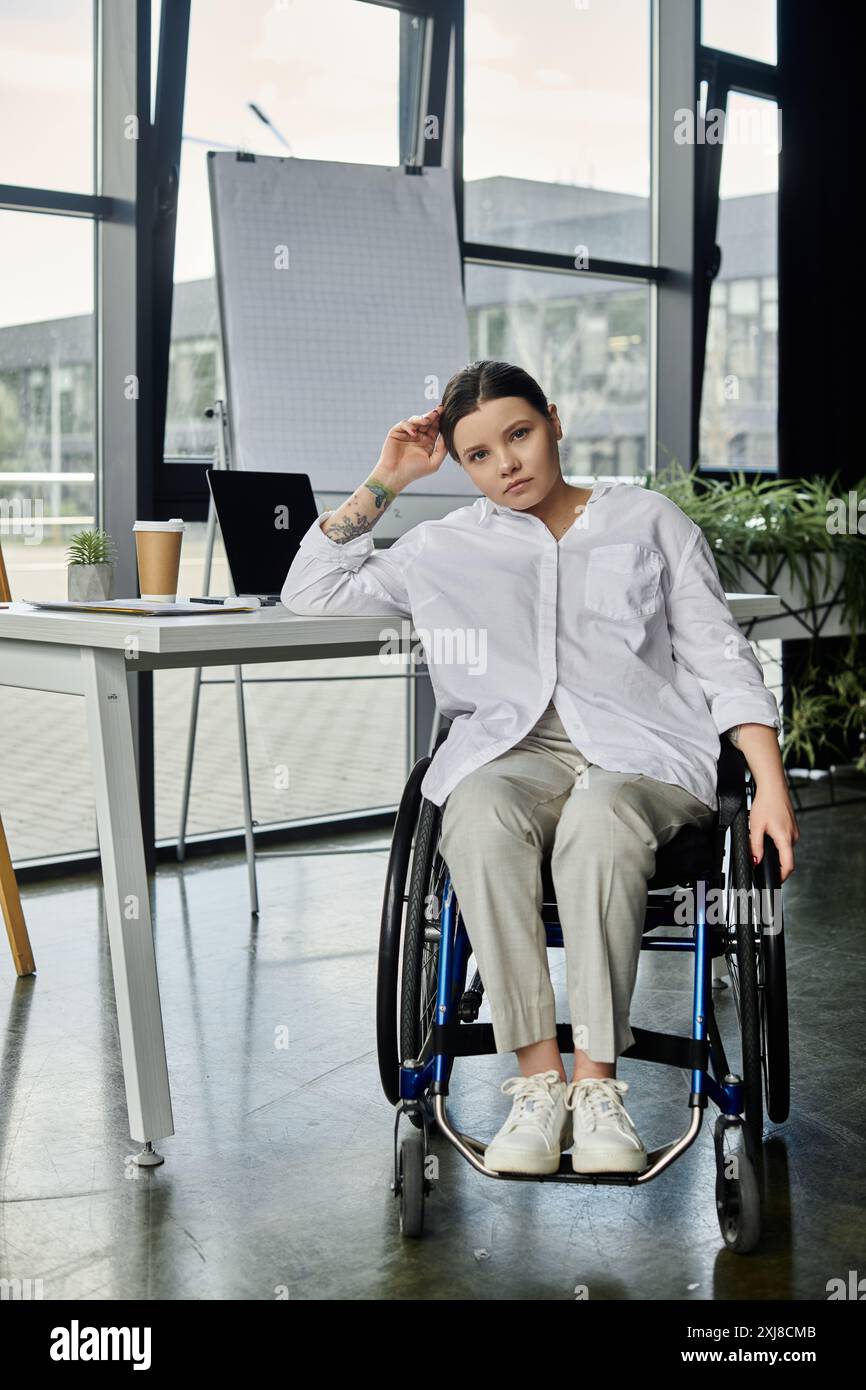 A young businesswoman with a disability sits in a wheelchair, working ...