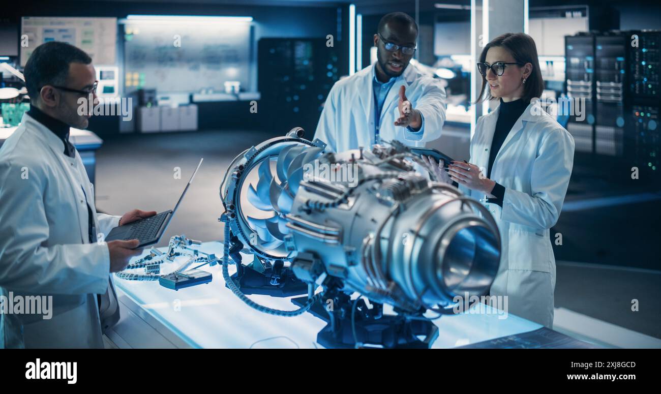 Airplane Engine Engineer and Scientist Work on a Futuristic Turbine Motor, Standing with Tablet ...