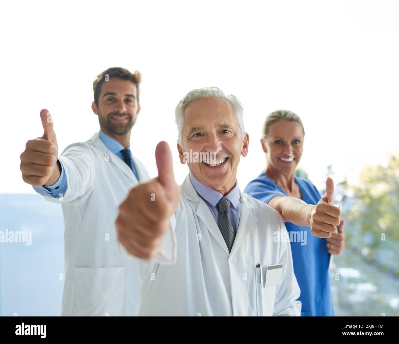 Portrait, doctors and man with thumbs up, teamwork and support in healthcare agreement in clinic ...