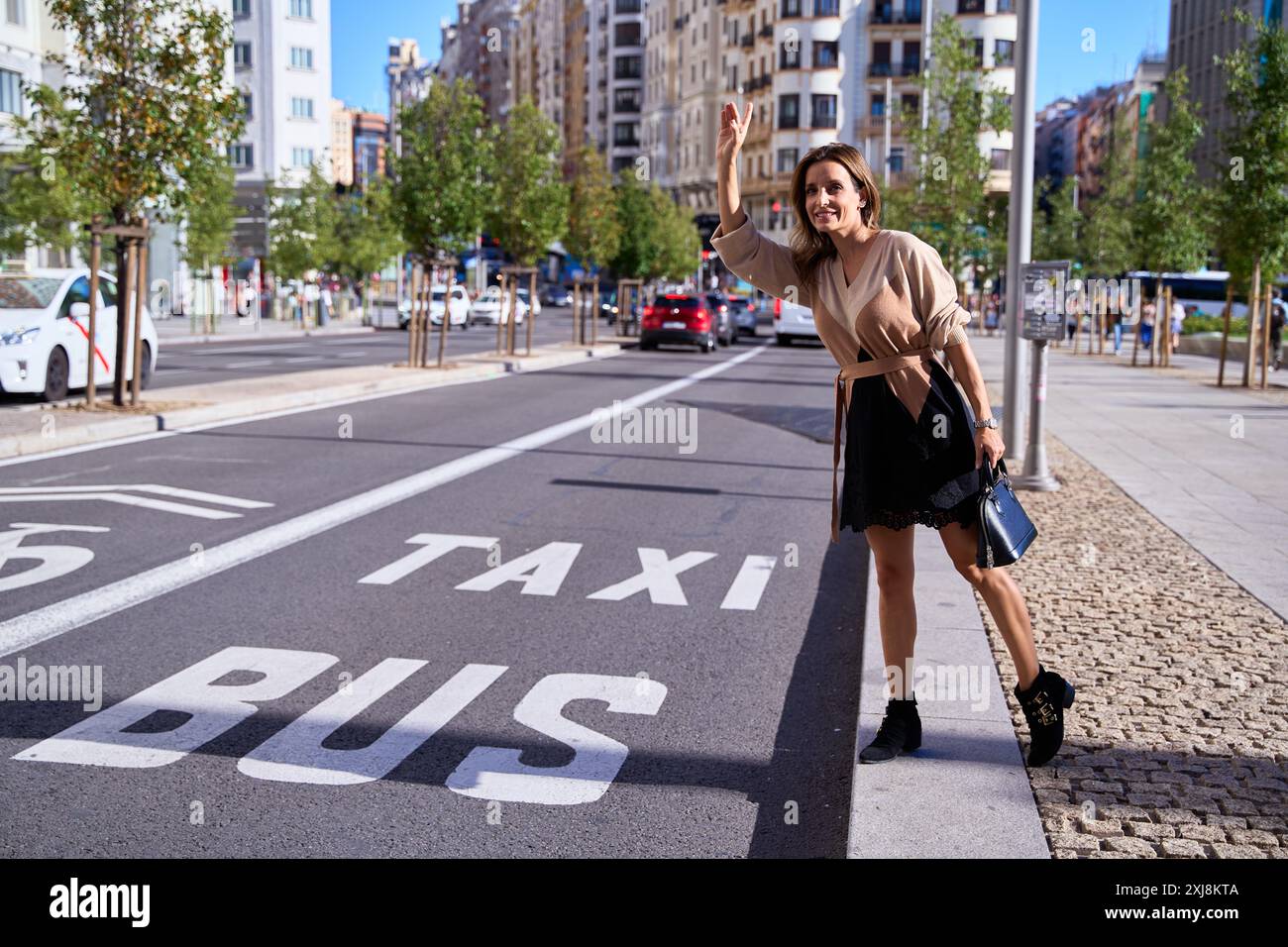 full length photo of beautiful woman beckoning the bus in the busy city ...