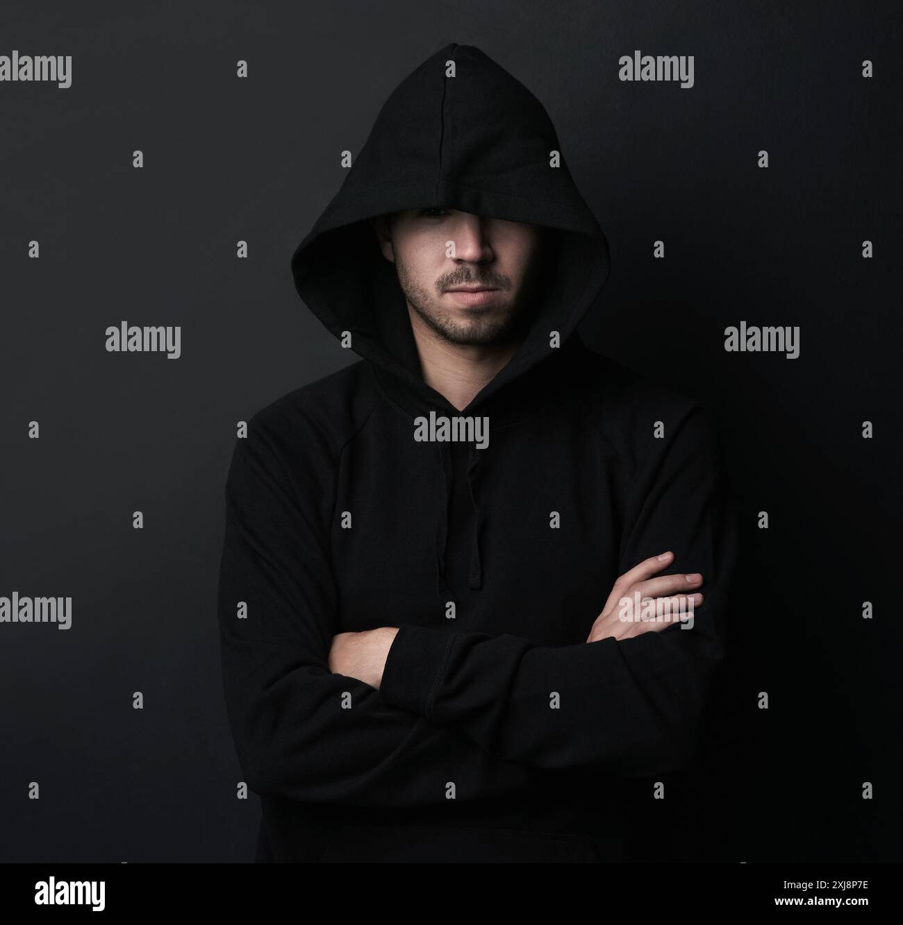 Dark, hoodie and man in studio, hiding and undercover for stalking ...