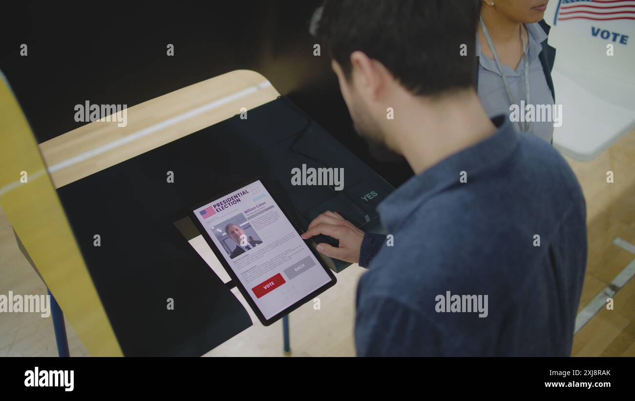 High angle of man making choice and voting for presidential candidate ...