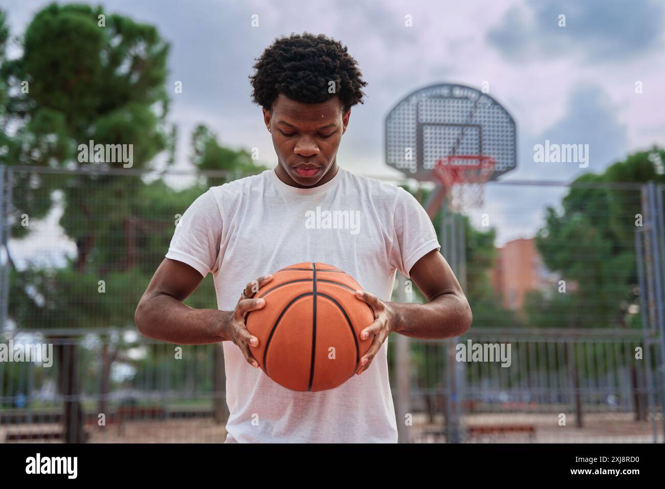 Young handsome african american man basketball player holding ball with ...