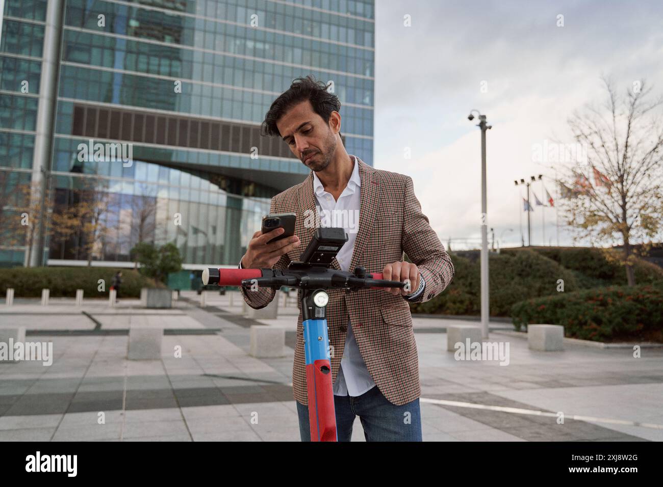 businessman scanning the qr code of an electric scooter with his smart ...