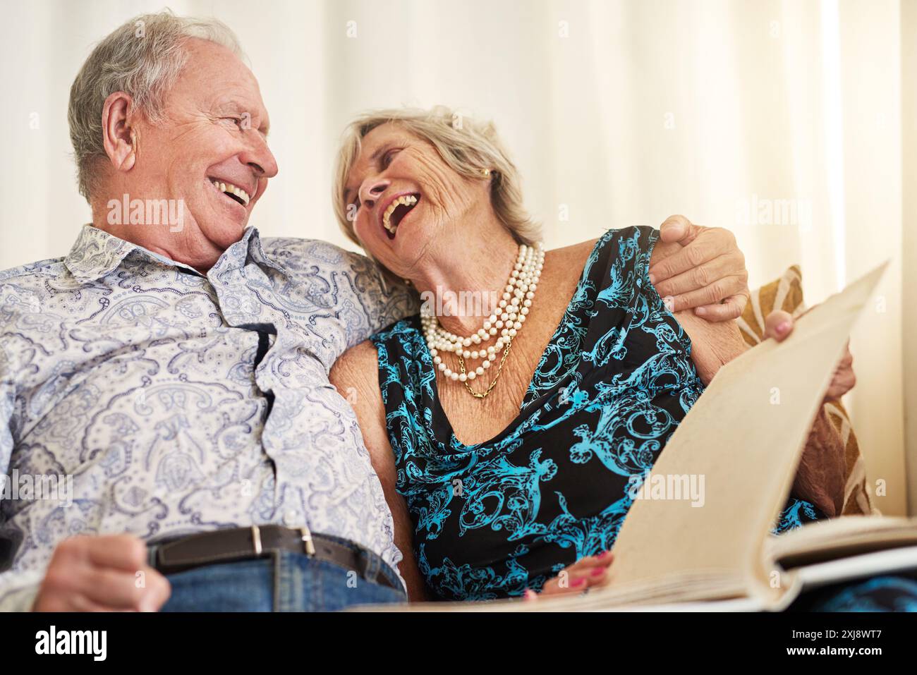 Laughing, photo album and wedding with senior couple on sofa in living ...