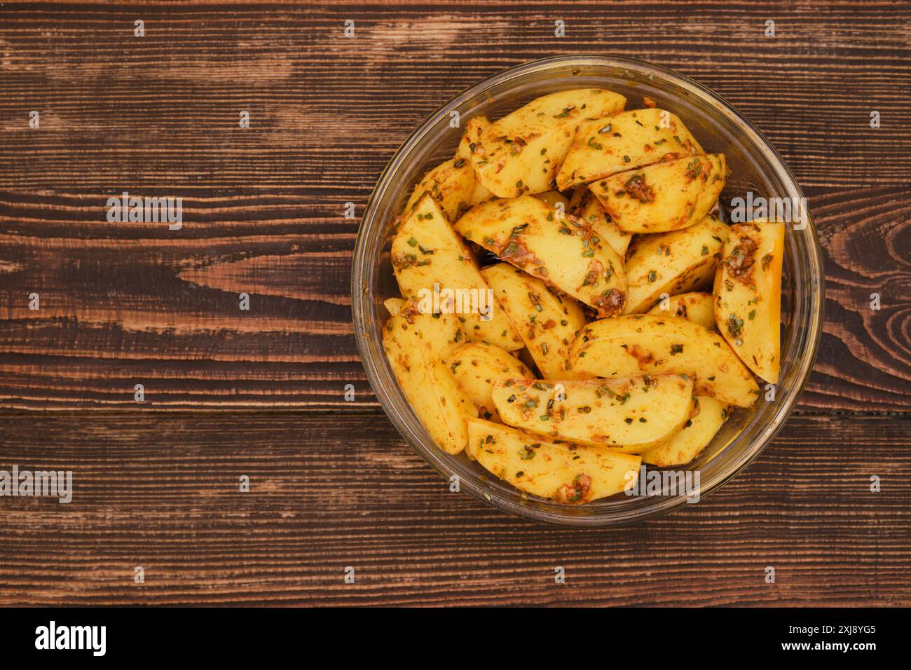 Marinated potato wedges seasoned with herbs, garlic and smoked paprica ...