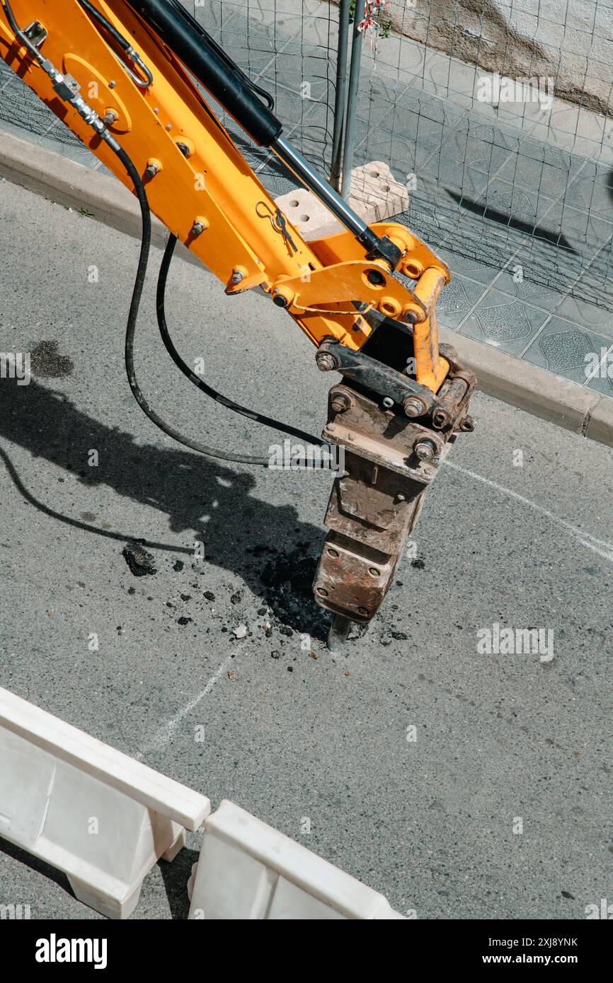 an excavator-mounted hydraulic jackhammer in use to break up the ...
