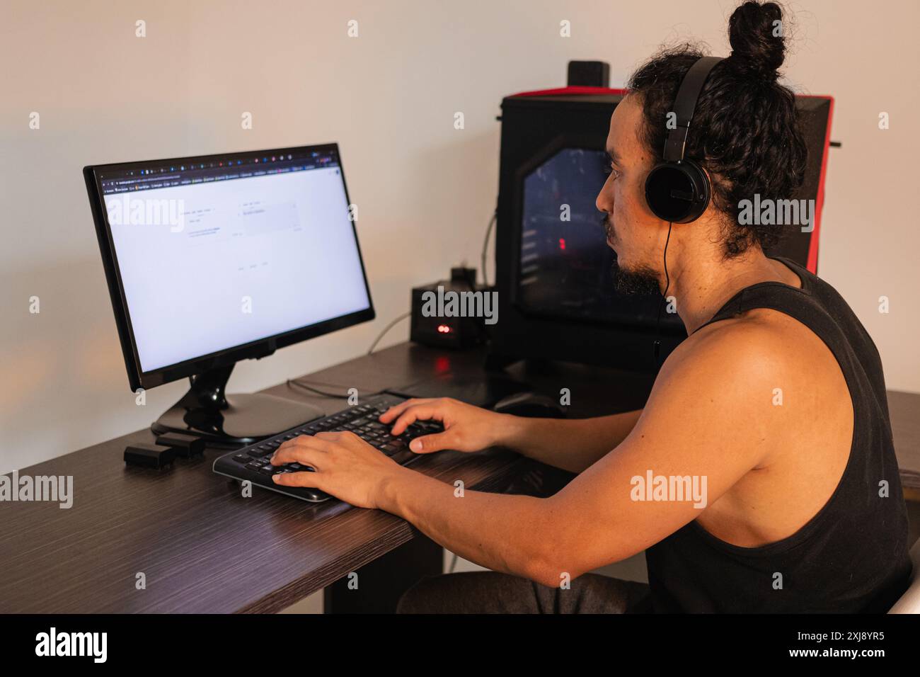 A young adult works from home as an audiovisual editor, creating ...