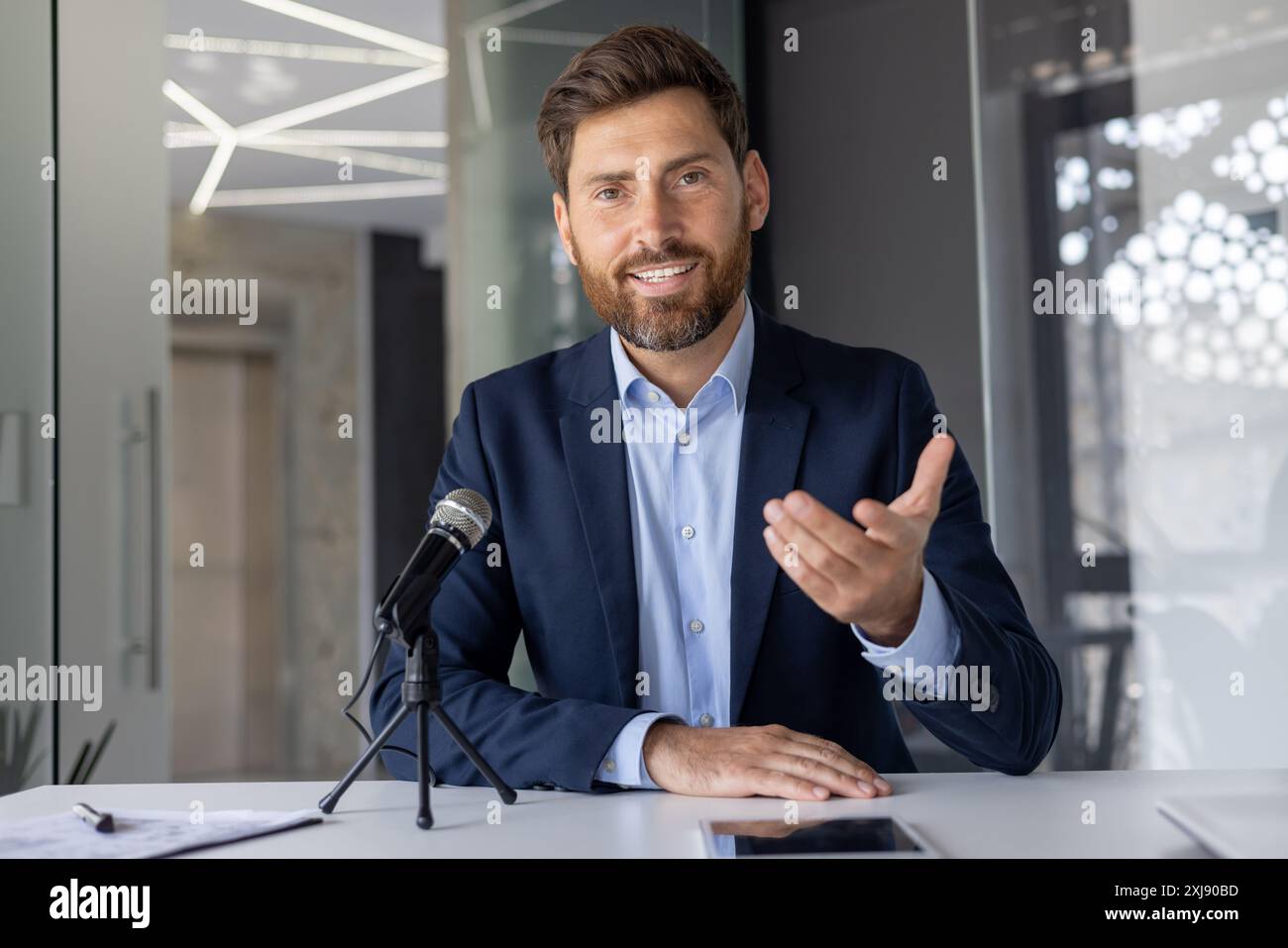 A professional male business speaker confidently addresses an audience ...