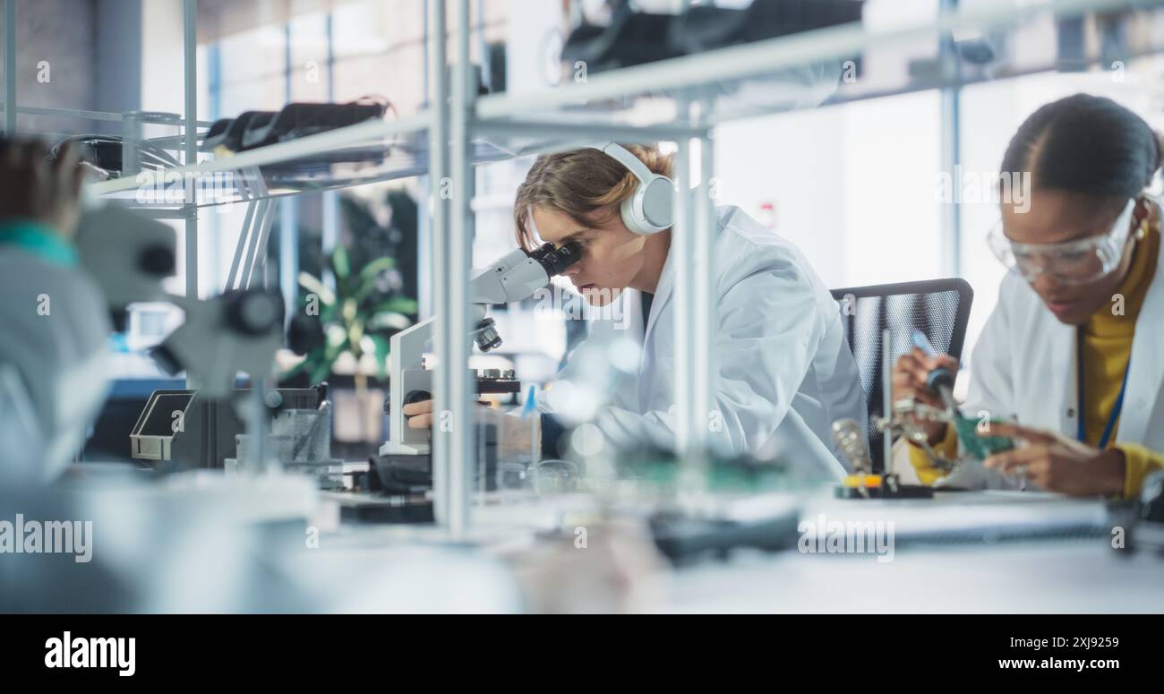 Team of Multiethnic Science Students Conducting Electronics Experiments ...