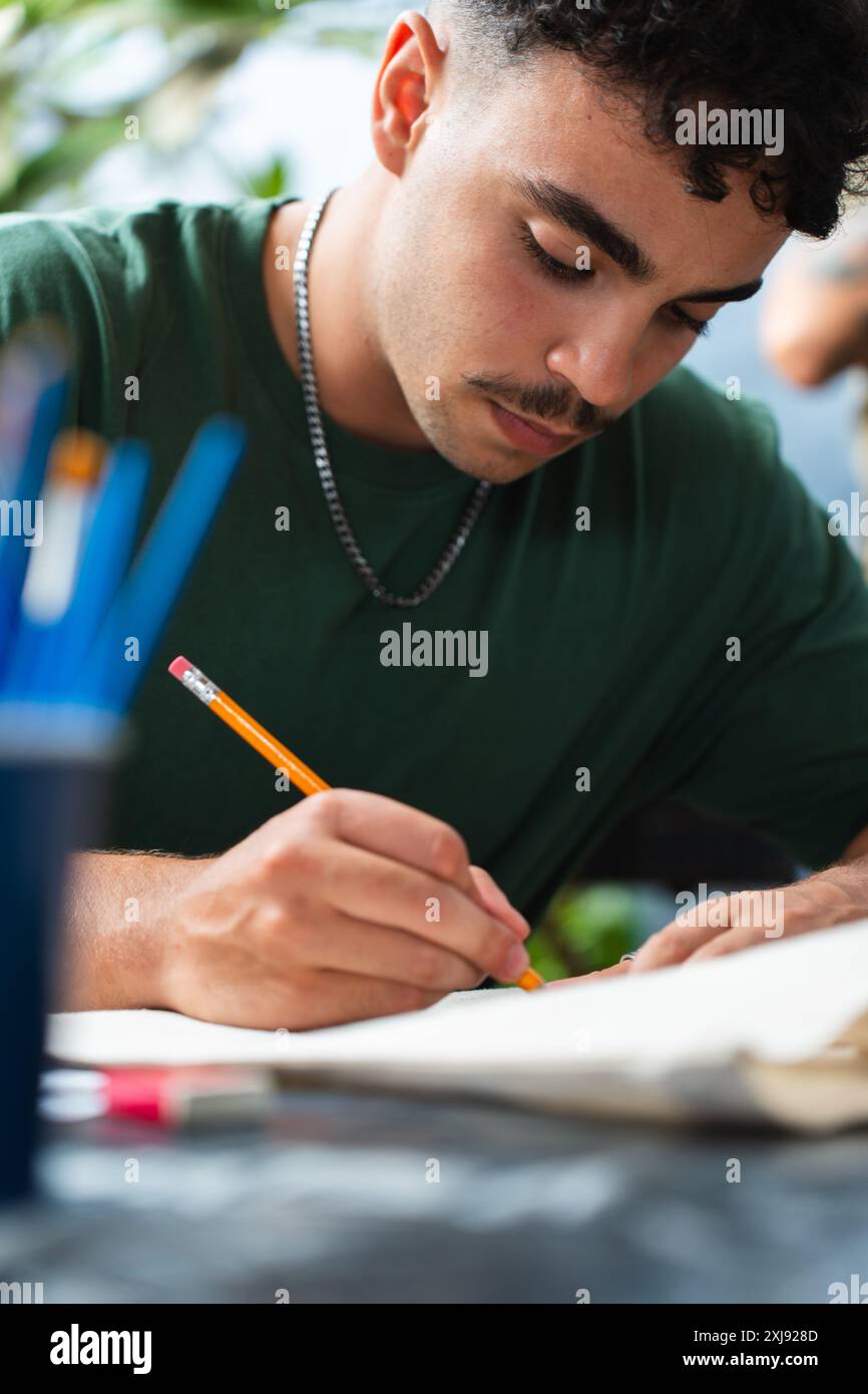 Classmate drawing with a very concentrated pencil during the fine arts ...