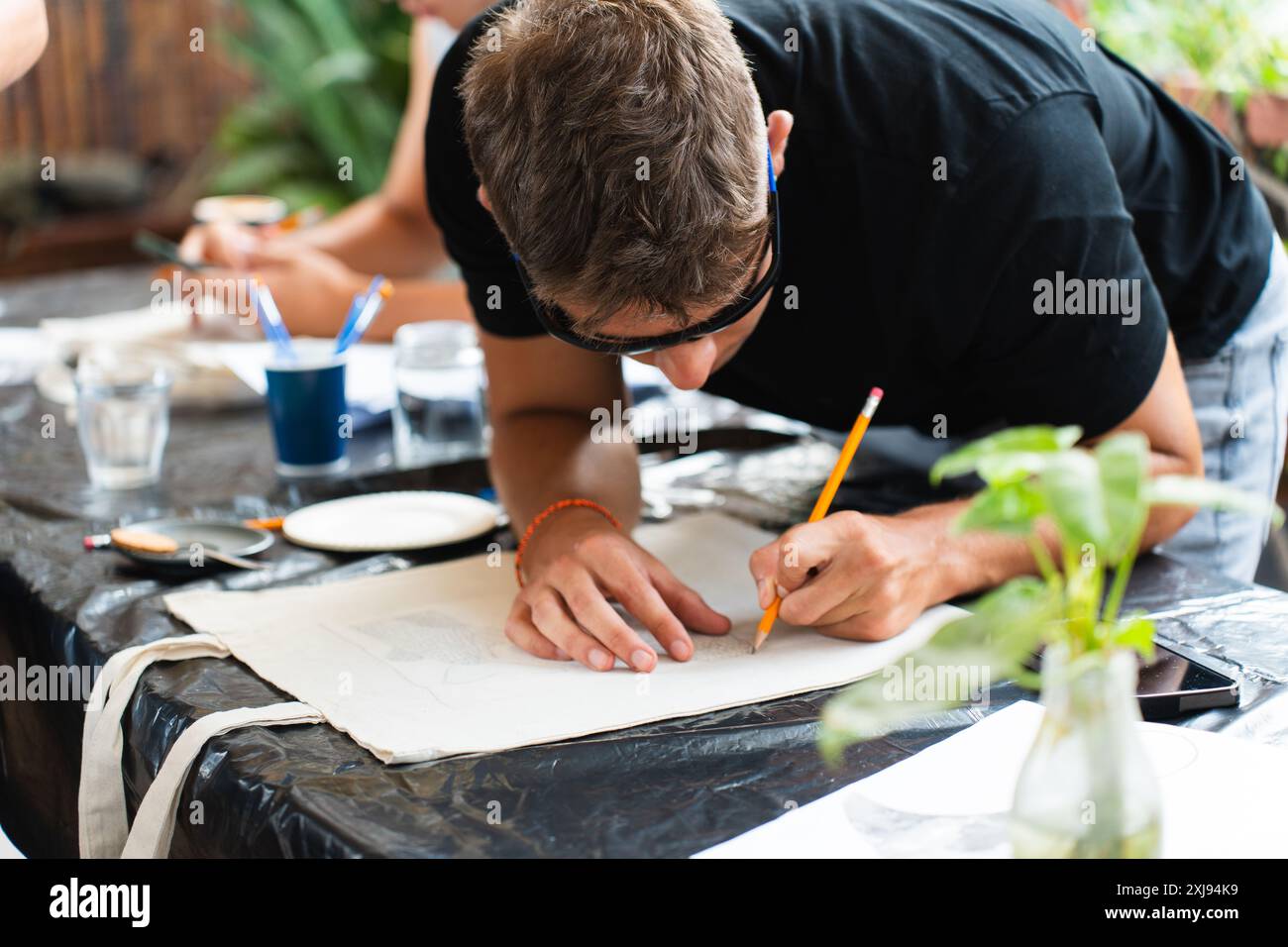 Man with sunglasses drawing standing upright leaning on table Stock ...