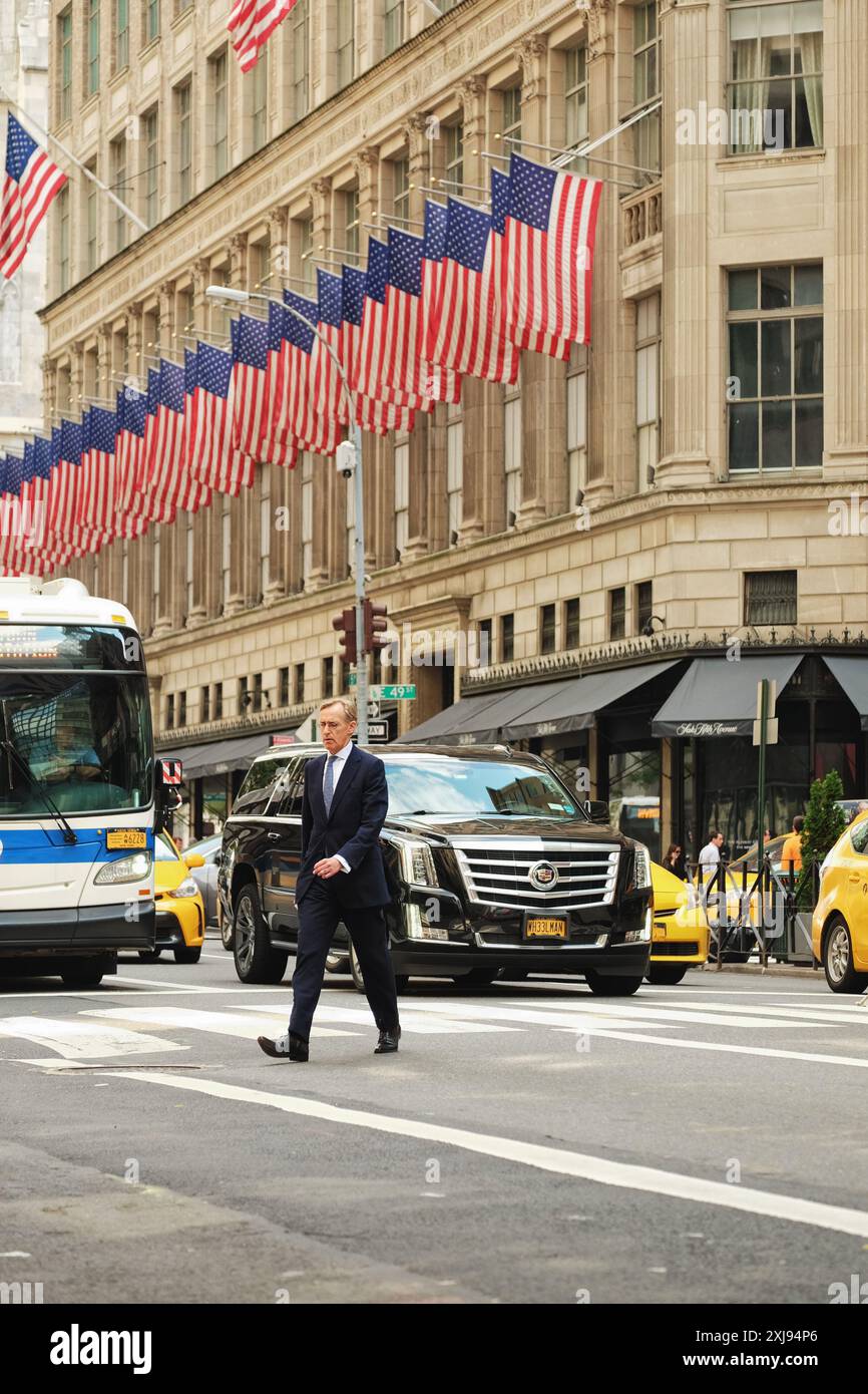 A businessman striding across 5th Avenue New York City, stopped traffic ...