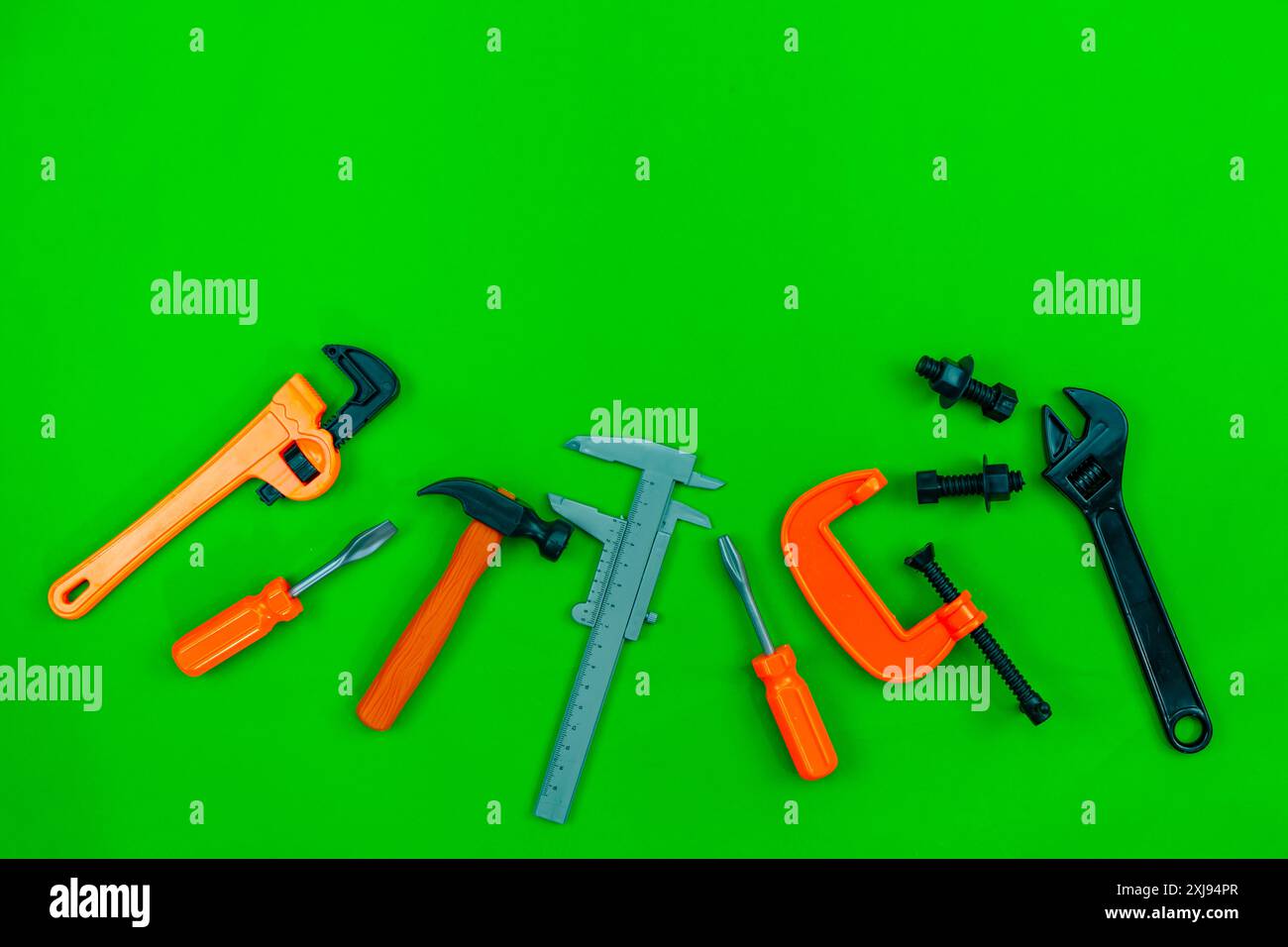 Set of toy working tools on colorful green paper background. Industrial ...