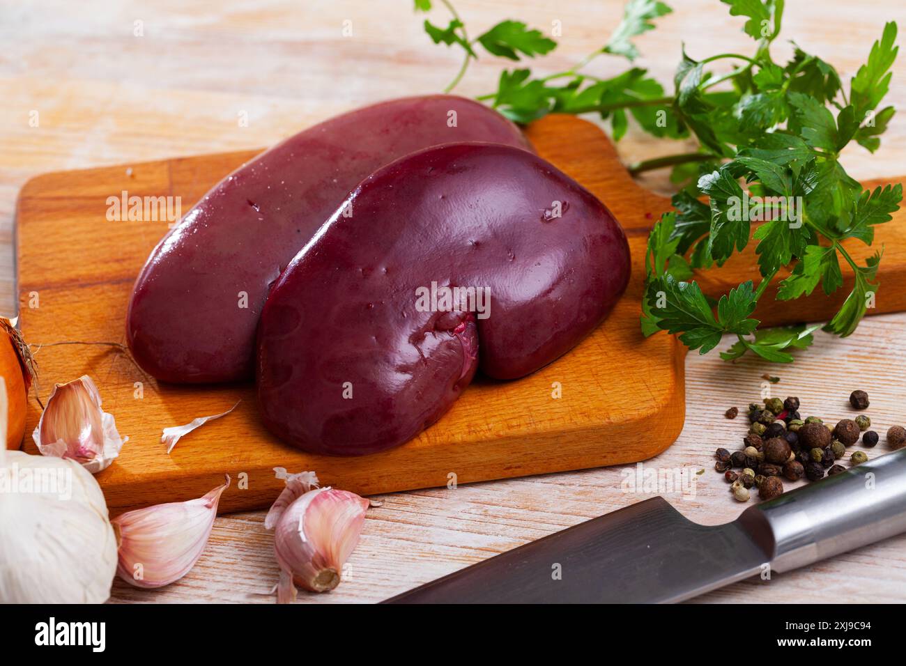 Raw pork kidney on wooden surface with garlic and greens Stock Photo ...