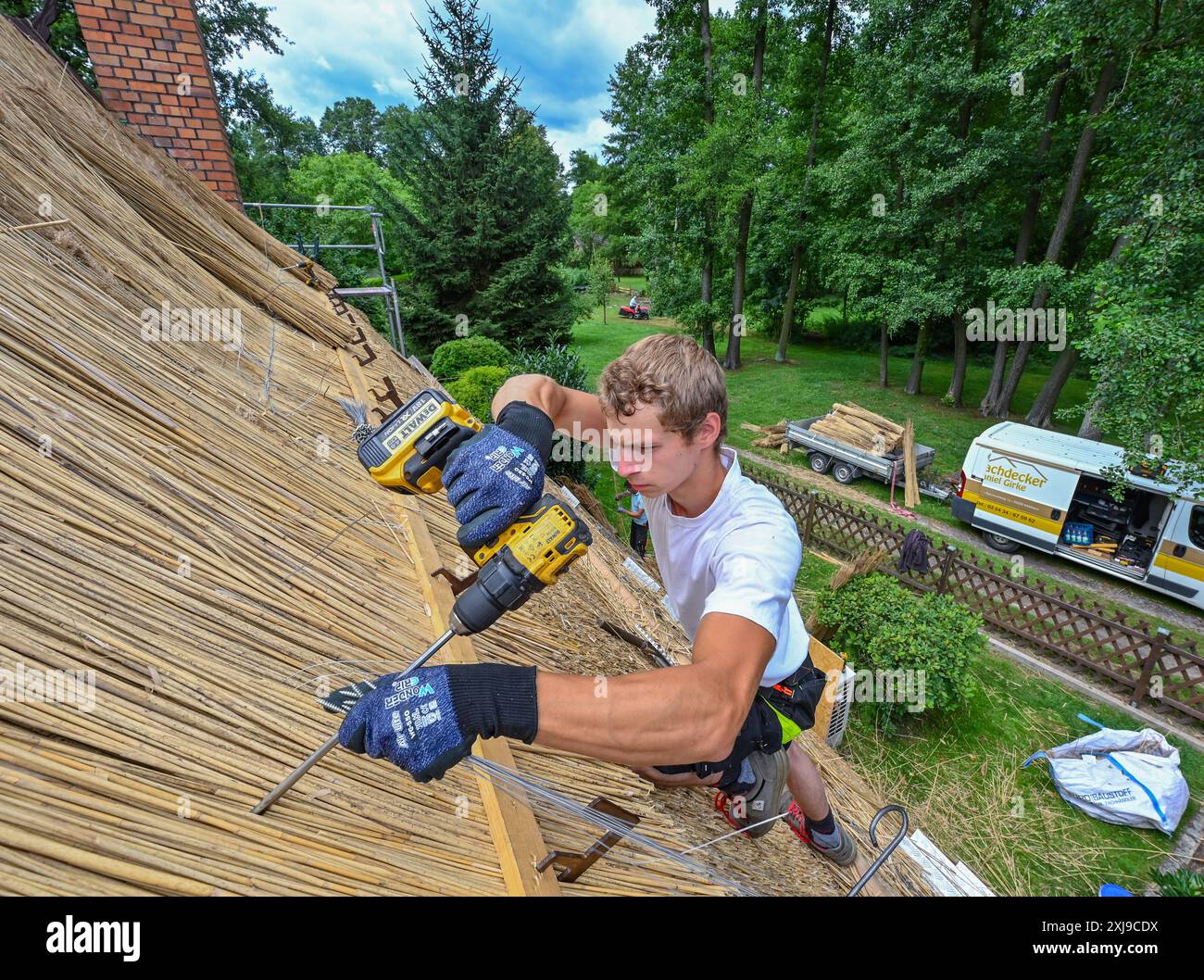 17 July 2024, Brandenburg, Burg (Spreewald): Pascal Herold, a roofer employed by master roofer ...