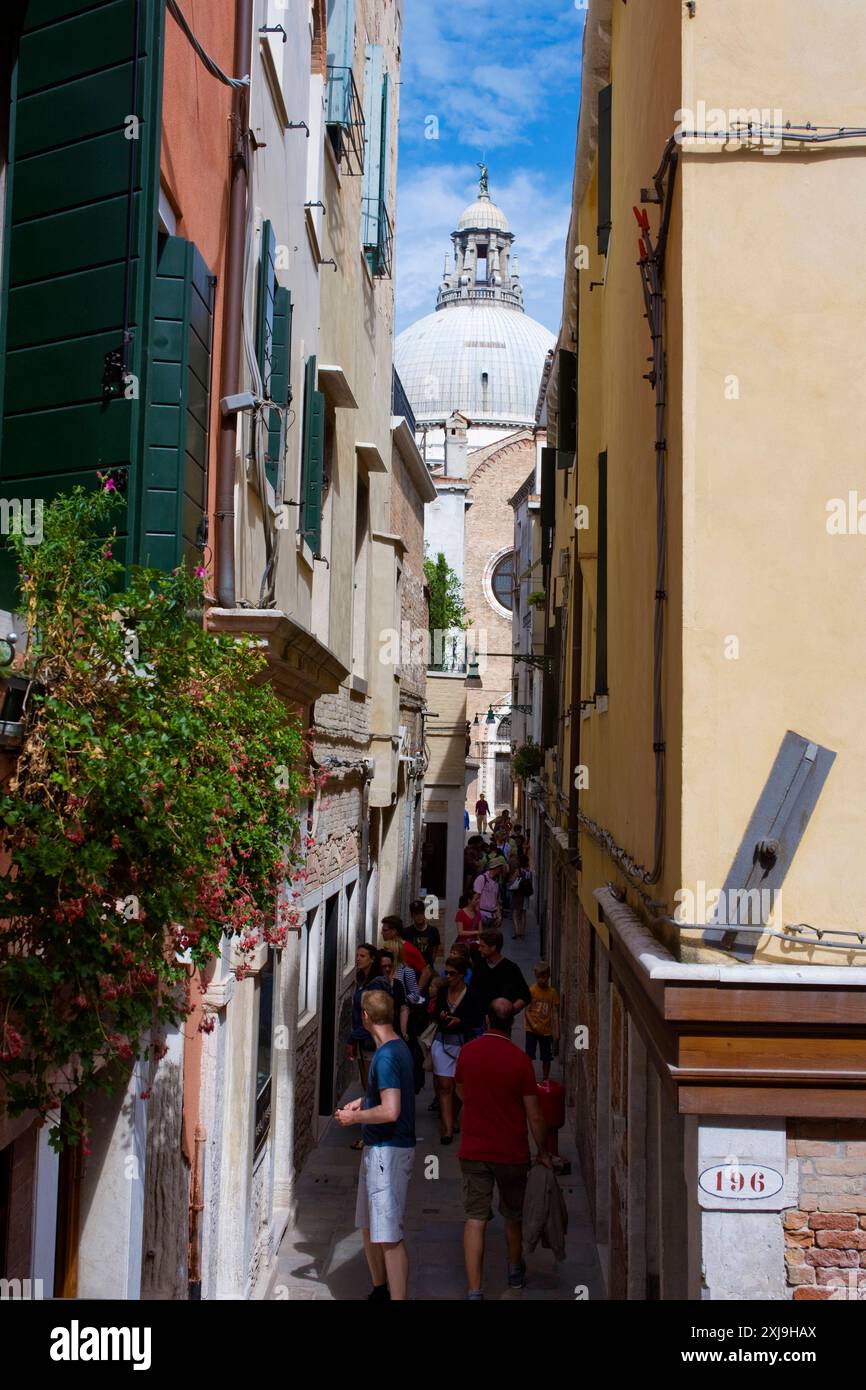 A narrow crowded alley leading to the Baroque-style Basilica de Santa ...