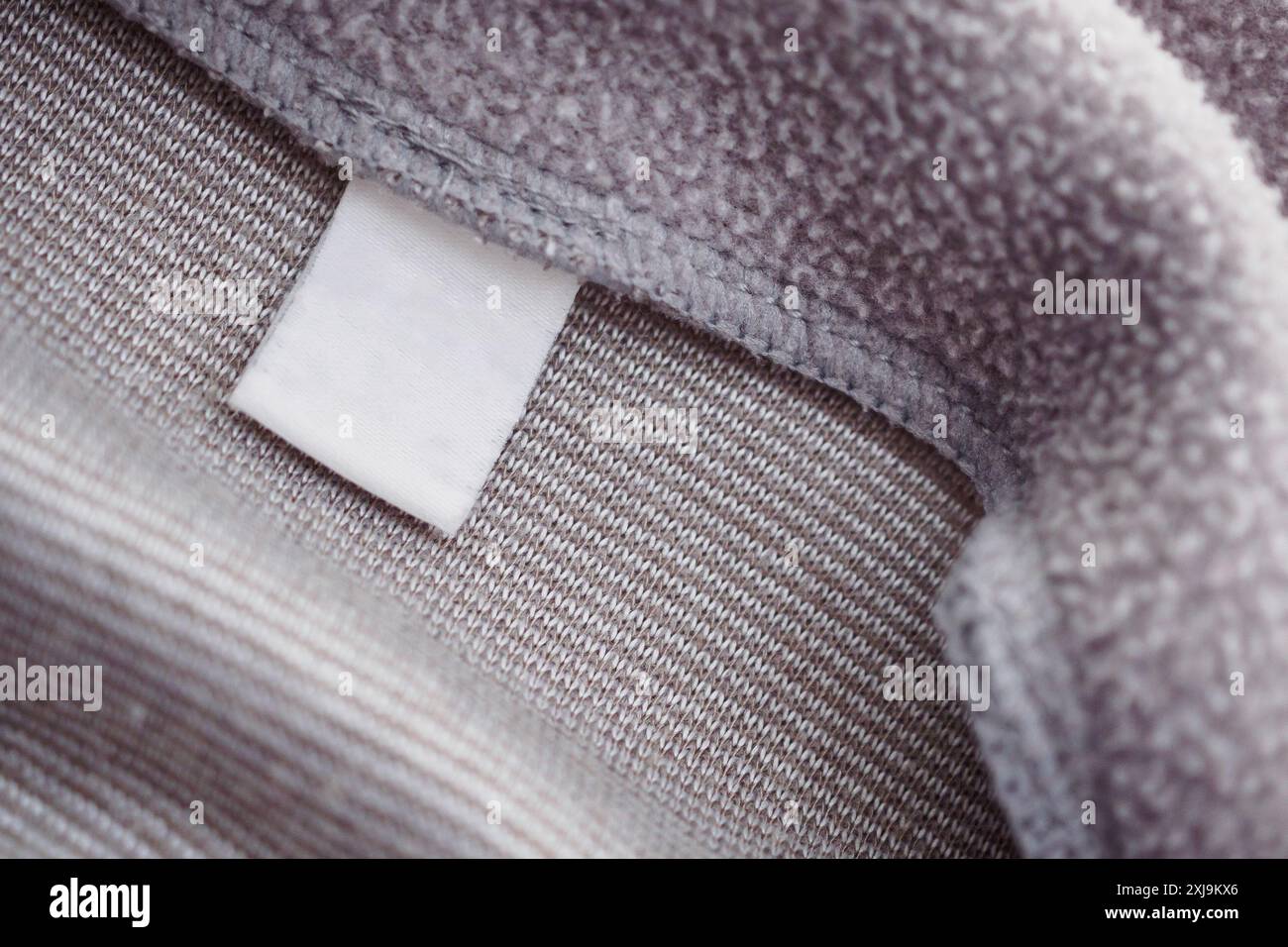blank white clothing label on gray fabric texture background Stock ...