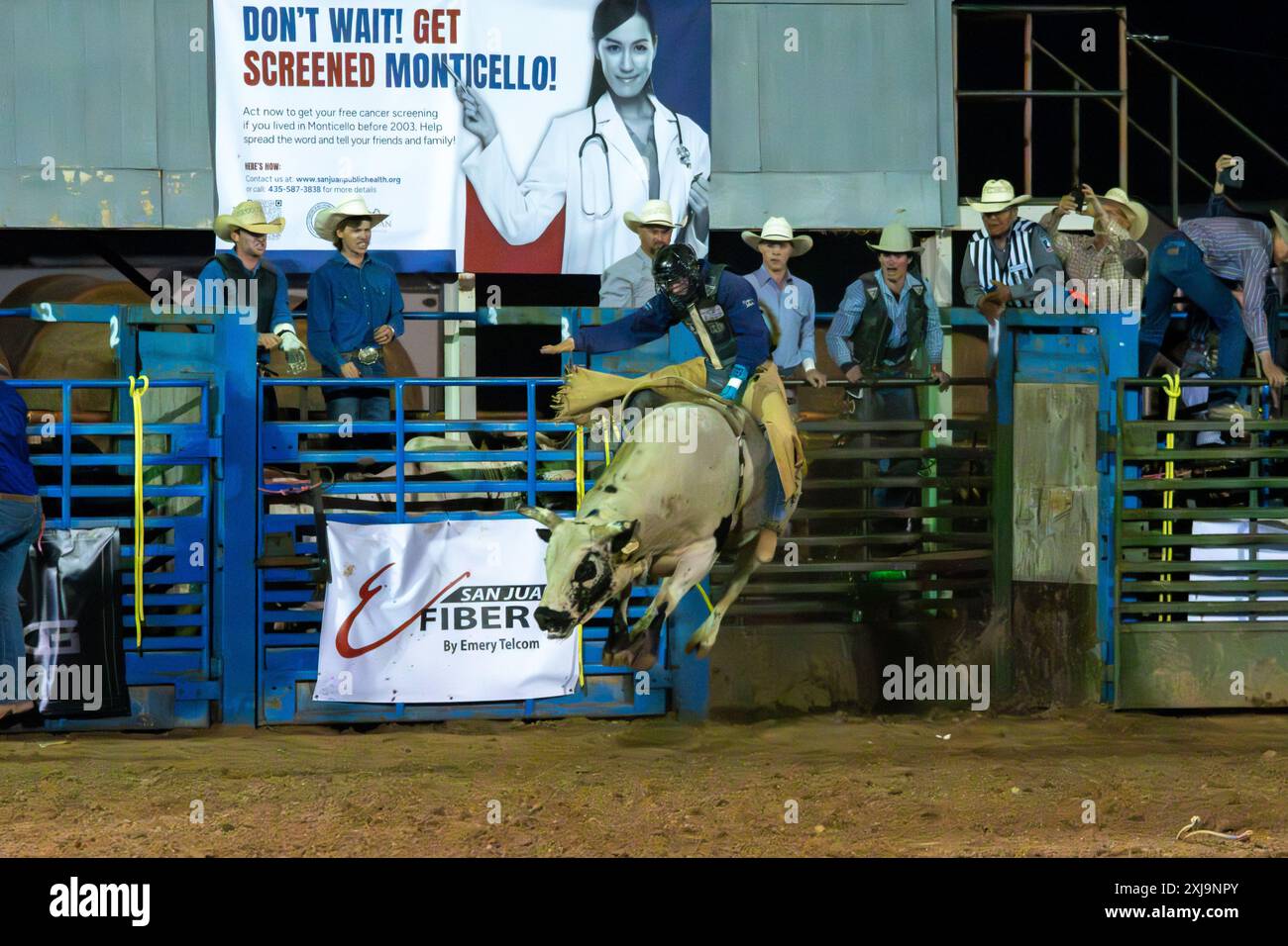 A professional rodeo cowboy rides a bull in a rodeo in a small town in ...