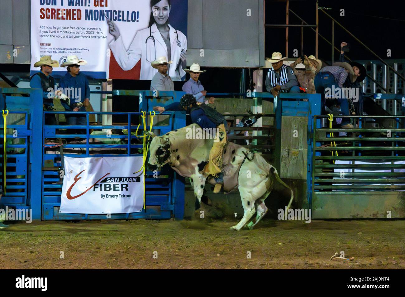 A professional rodeo cowboy rides a bull in a rodeo in a small town in ...