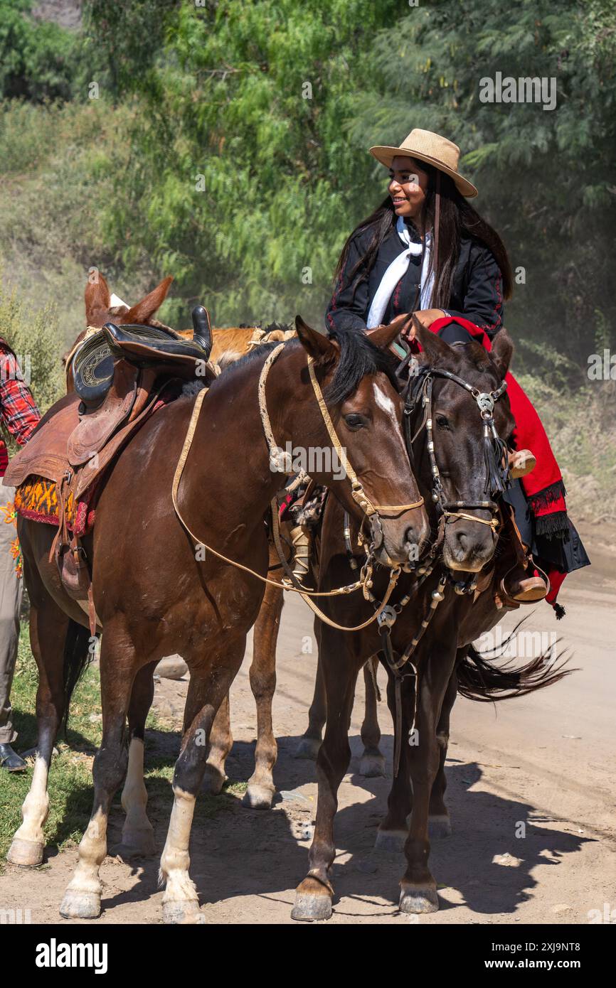A female gaucho in traditional dress riding sidesaddle in Cachi ...