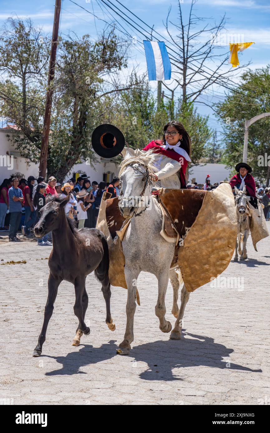 A female gaucho wearing a traditional red Salteño poncho in a parade in ...