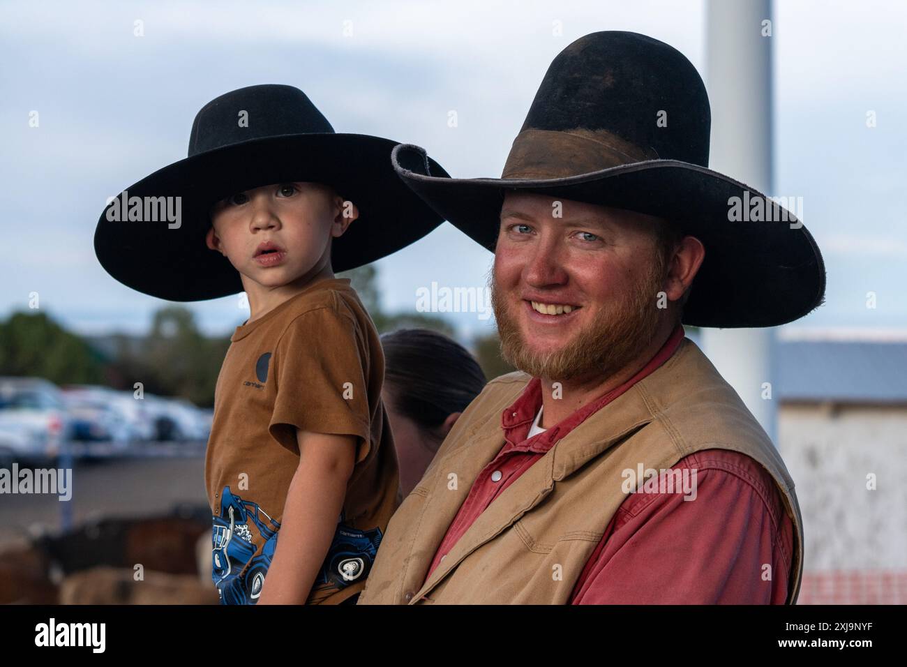 A rancher and his young son in flet cowboy hats attend a rodeo in a ...