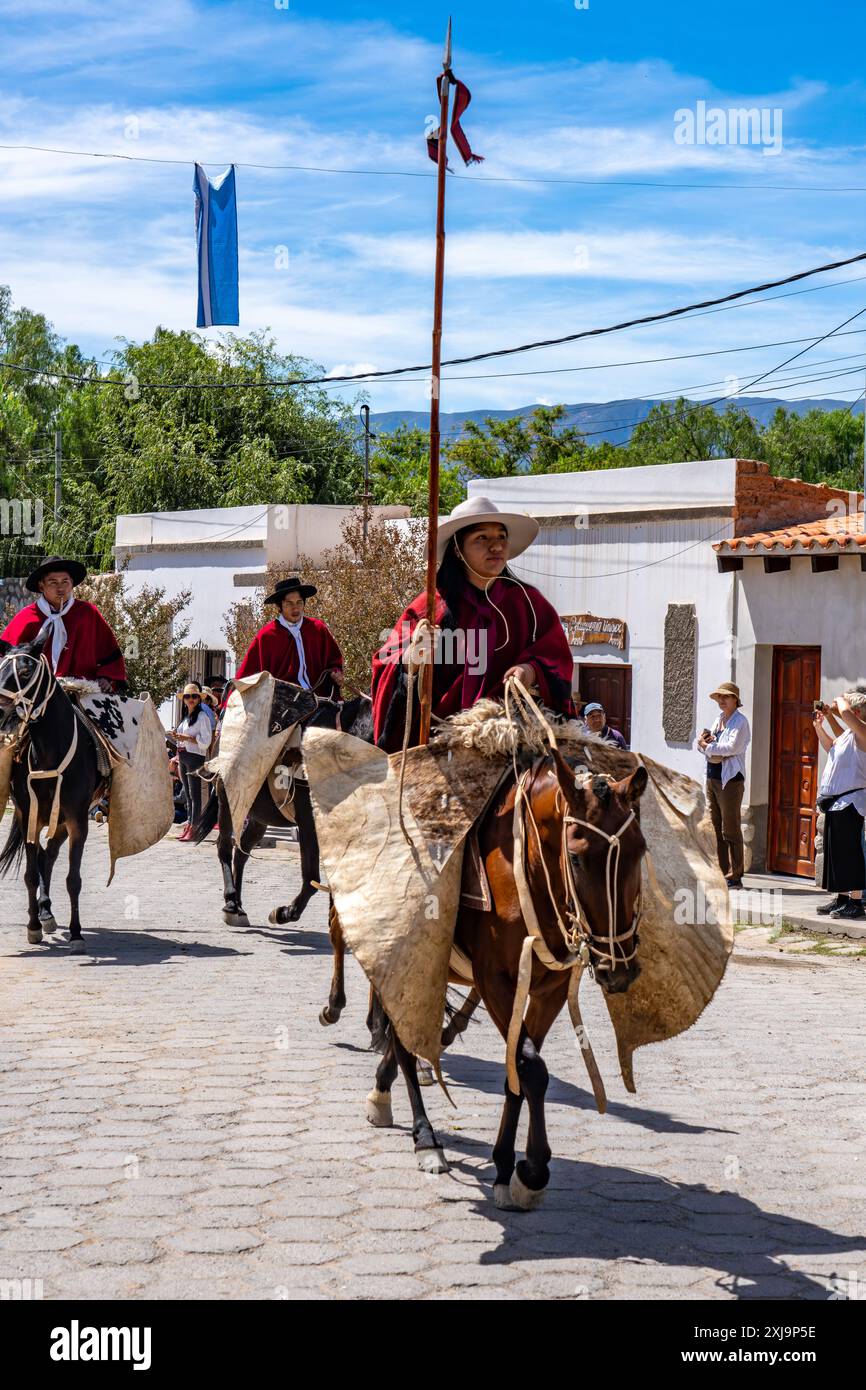 A female gaucho wearing a traditional red Salteño poncho in a parade in ...
