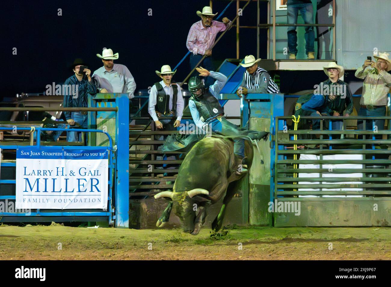 A professional rodeo cowboy rides a bull in a rodeo in a small town in ...