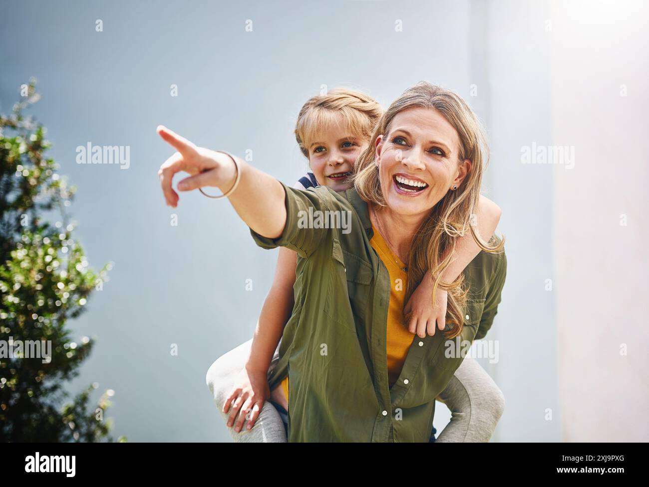 Happy mother, pointing and piggyback with daughter for bonding, holiday ...