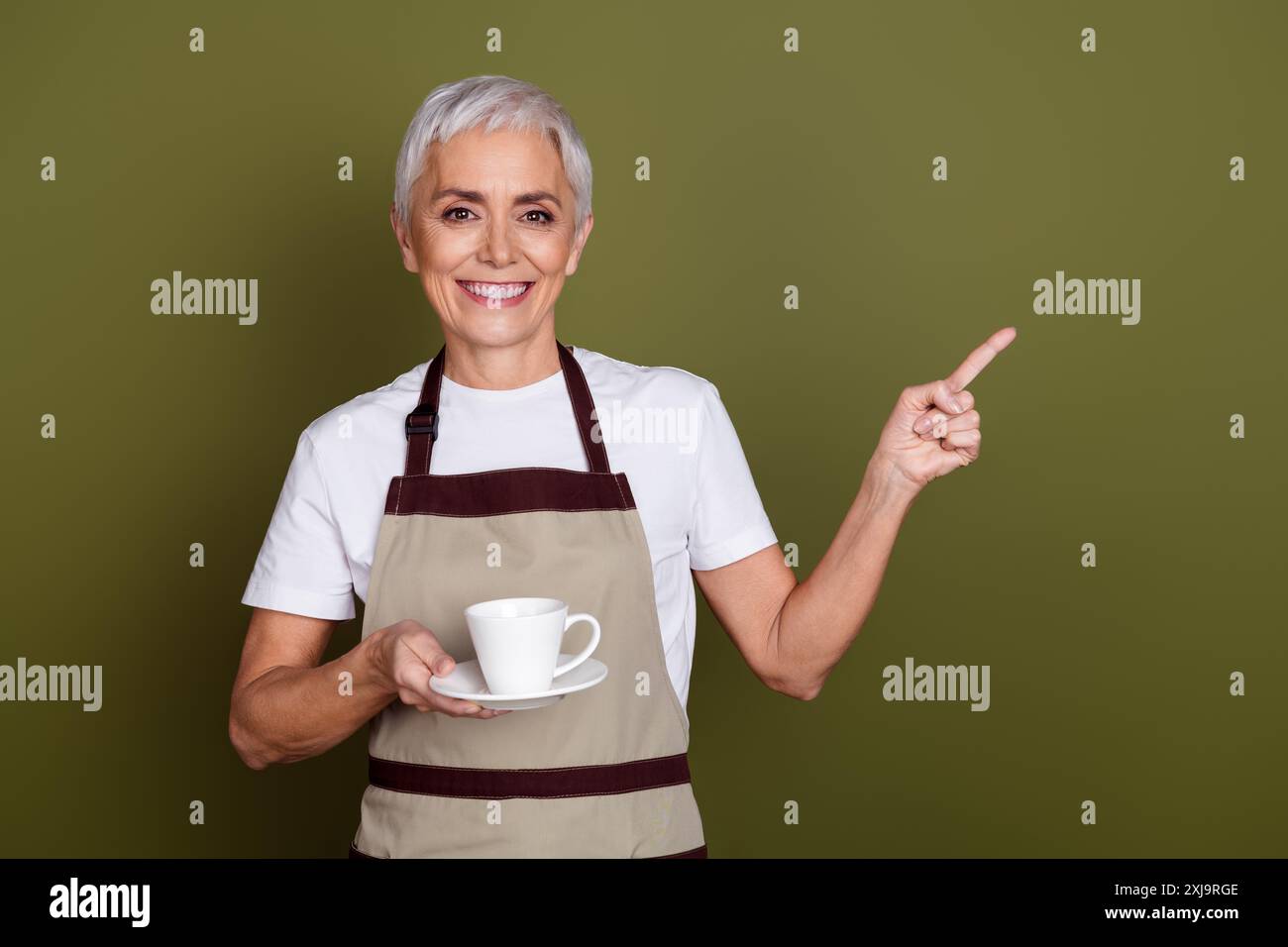 Photo of charming cute woman wear apron serving coffee pointing finger ...