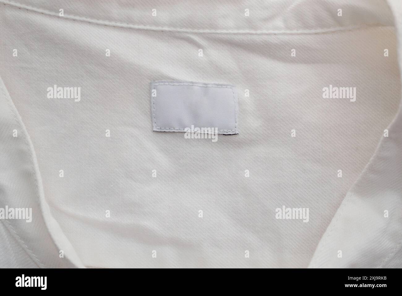 White blank clothing label on cotton shirt background Stock Photo - Alamy